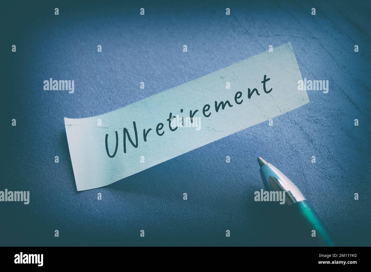 Unretirement word written on paper note with pen. Top view, flat lay on ...