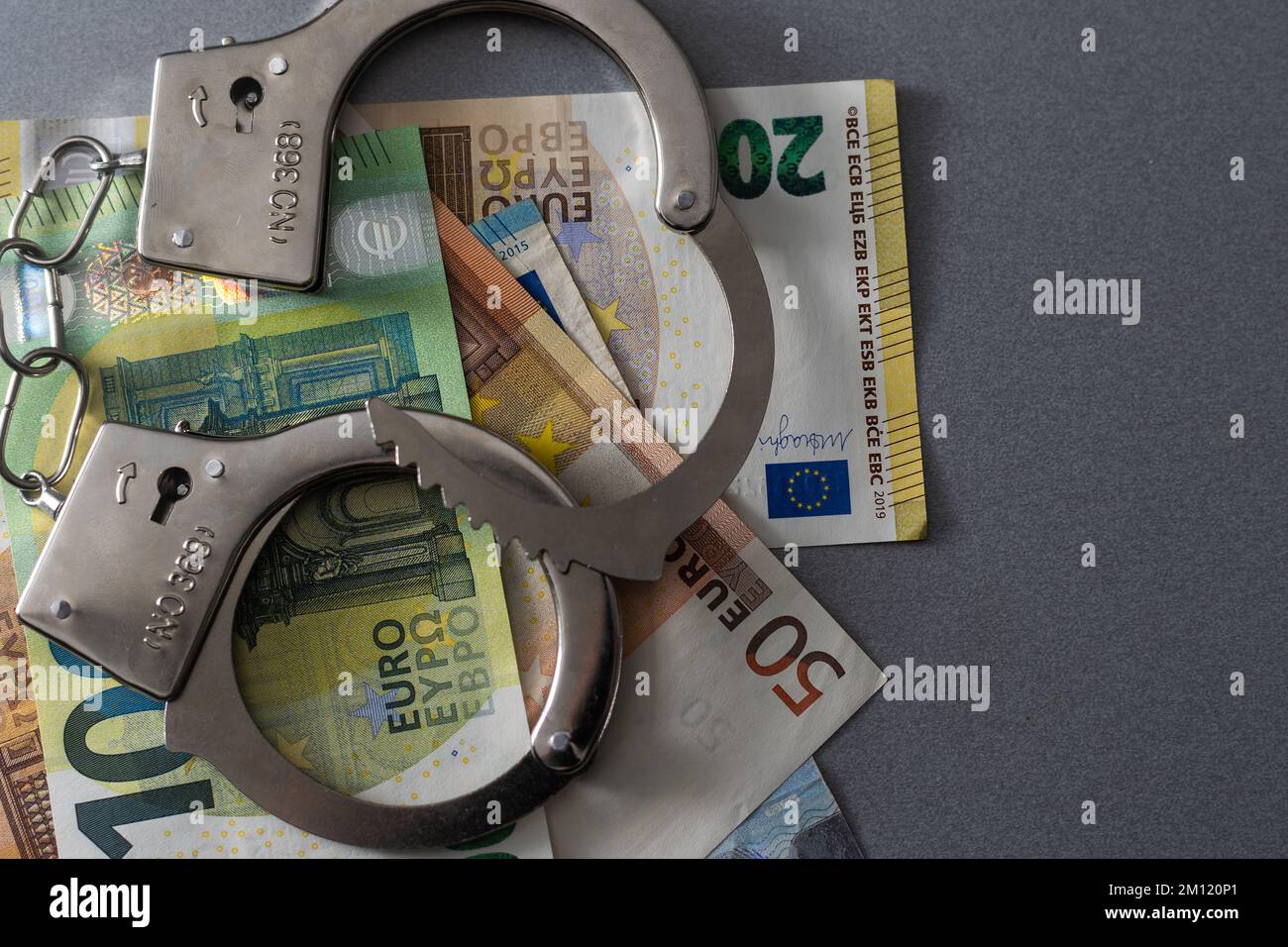 Police handcuffs lies on a set of green monetary denominations of 100 ...