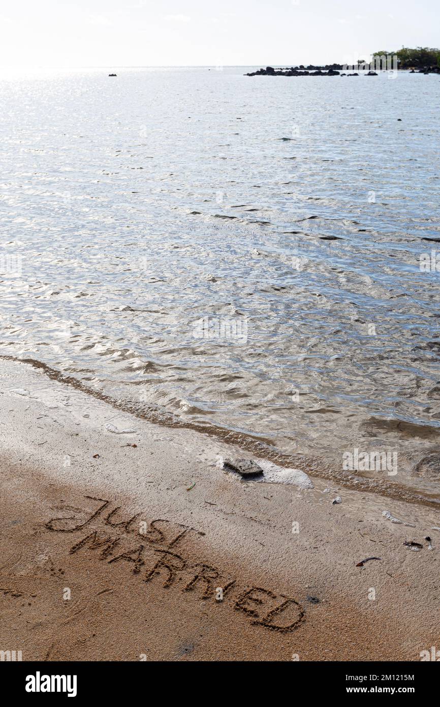 JUST MARRIED message written with a finger in the sand on a beach with ...