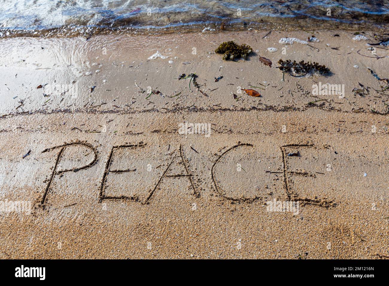 Peace - as a message written with a finger in the sand on a beach with ...