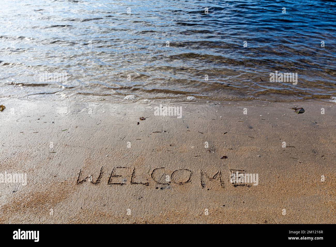 WELCOME - as a message written with a finger in the sand on a beach ...