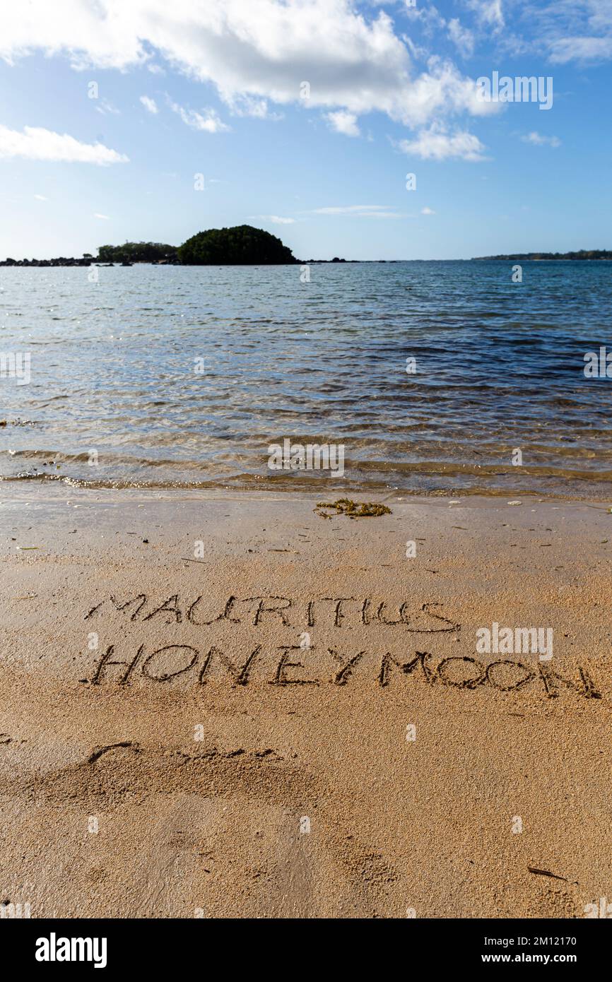 MAURITIUS HONEYMOON message written with a finger in the sand on a ...