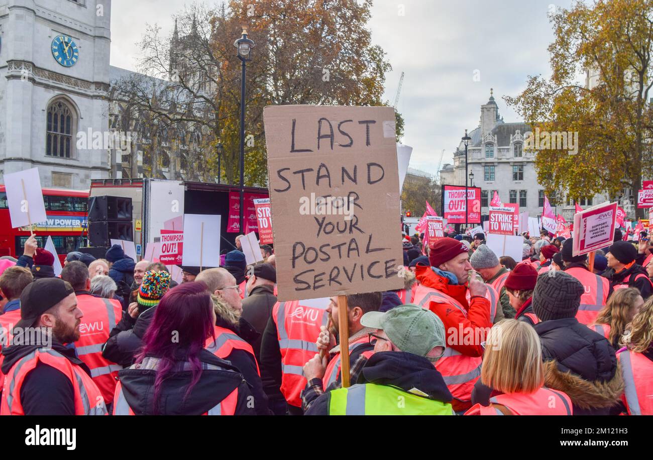 A protester holds a placard which states 'Last stand for your postal ...
