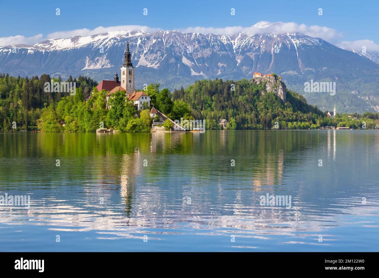 View of lake Bled at in spring with the small island and Assumption of ...