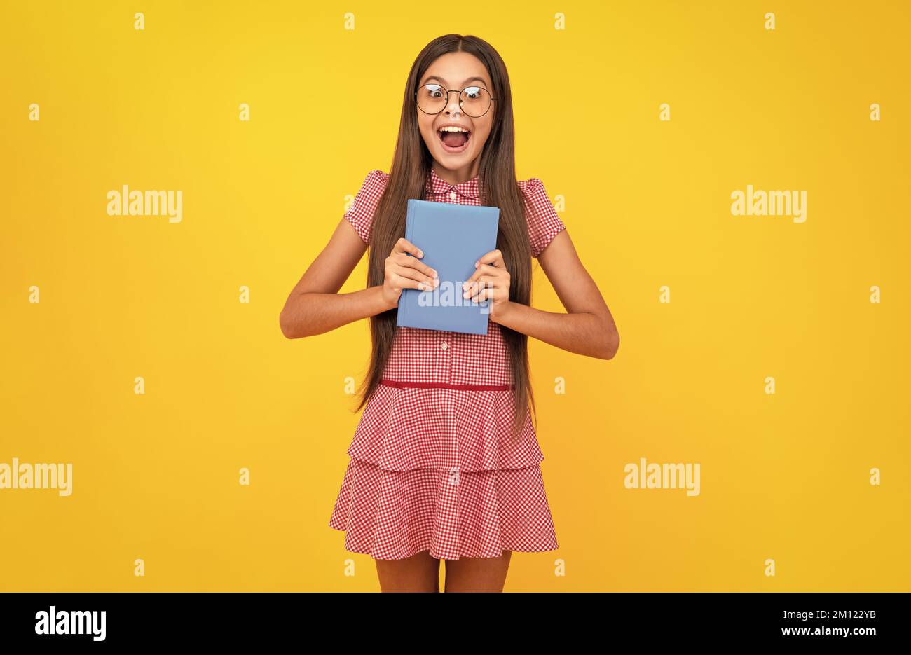 Amazed teen girl. Schoolgirl with copy book posing on isolated ...