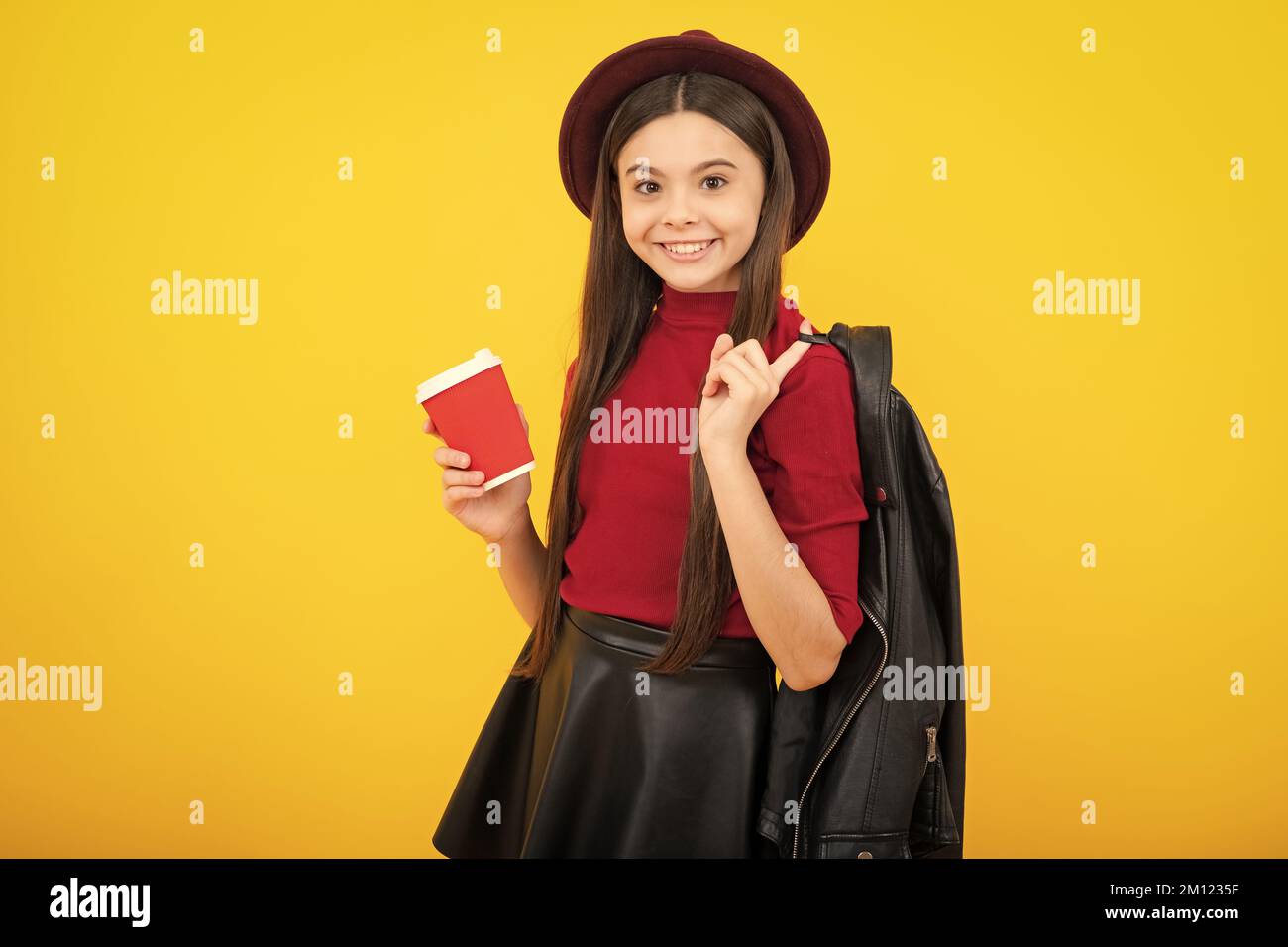 Teenager child with coffee cup isolated on yellow studio background ...