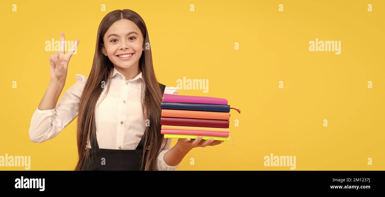 happy teen girl in school uniform hold book stack show peace gesture ...