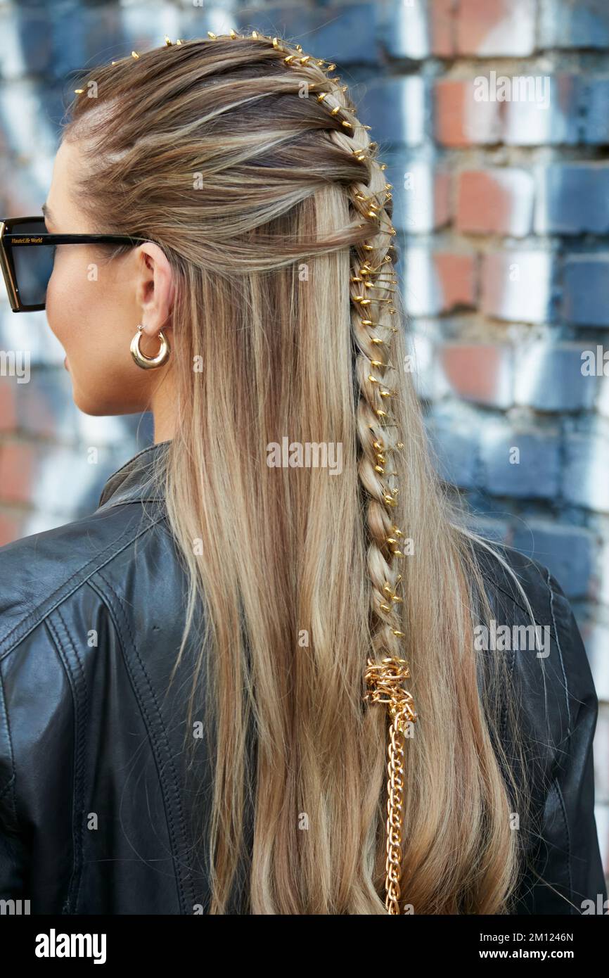 MILAN, ITALY - SEPTEMBER 21, 2022: Woman with braid with golden safety ...