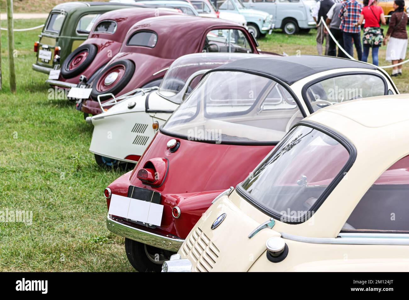 The view of several classic cars parked in a row during an outdoor ...