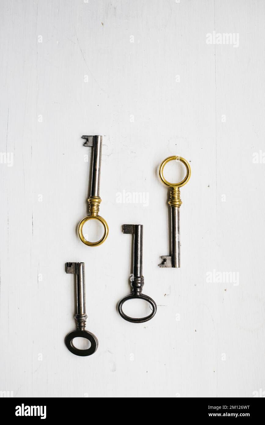 Four old keys on a white wooden surface hi-res stock photography and ...