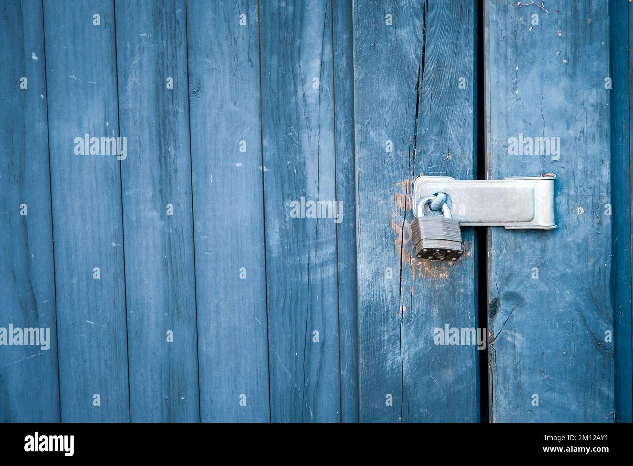 Old padlock and blue boards keep door locked Stock Photo - Alamy