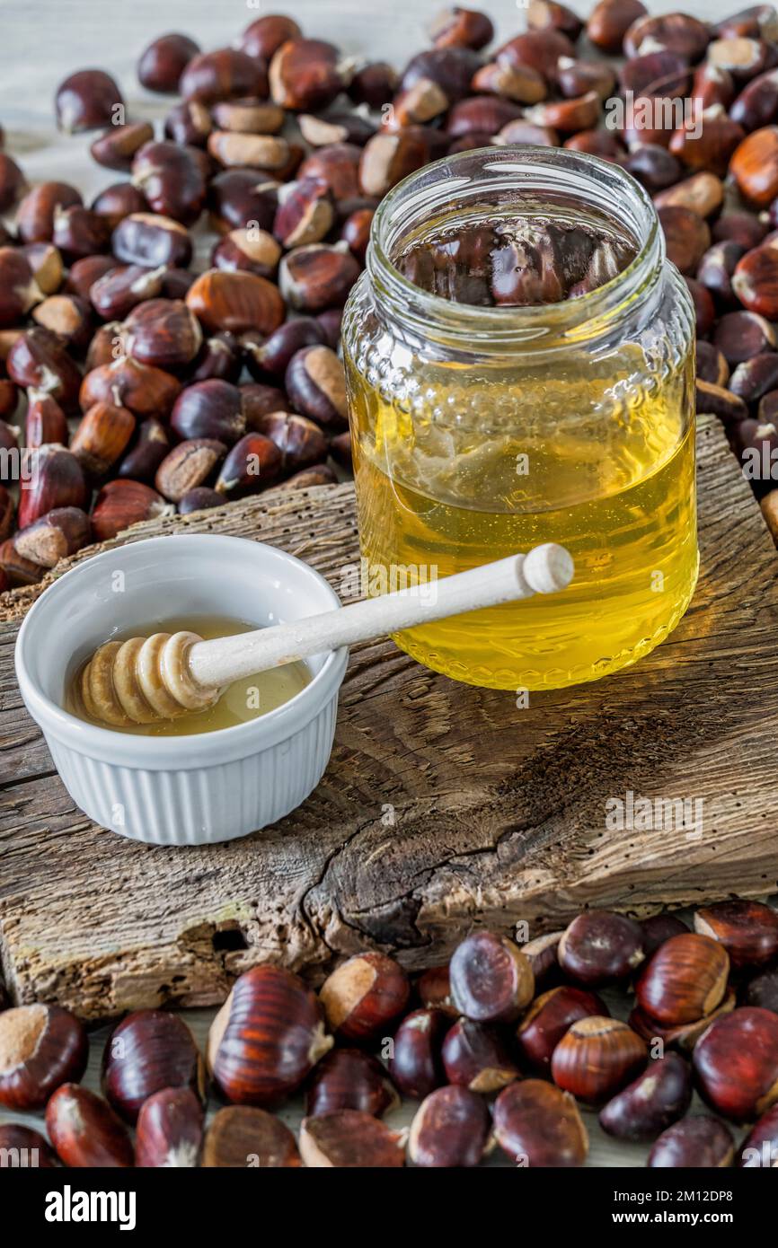 jar of bee honey with small cup and honey dipper on antique wooden ...