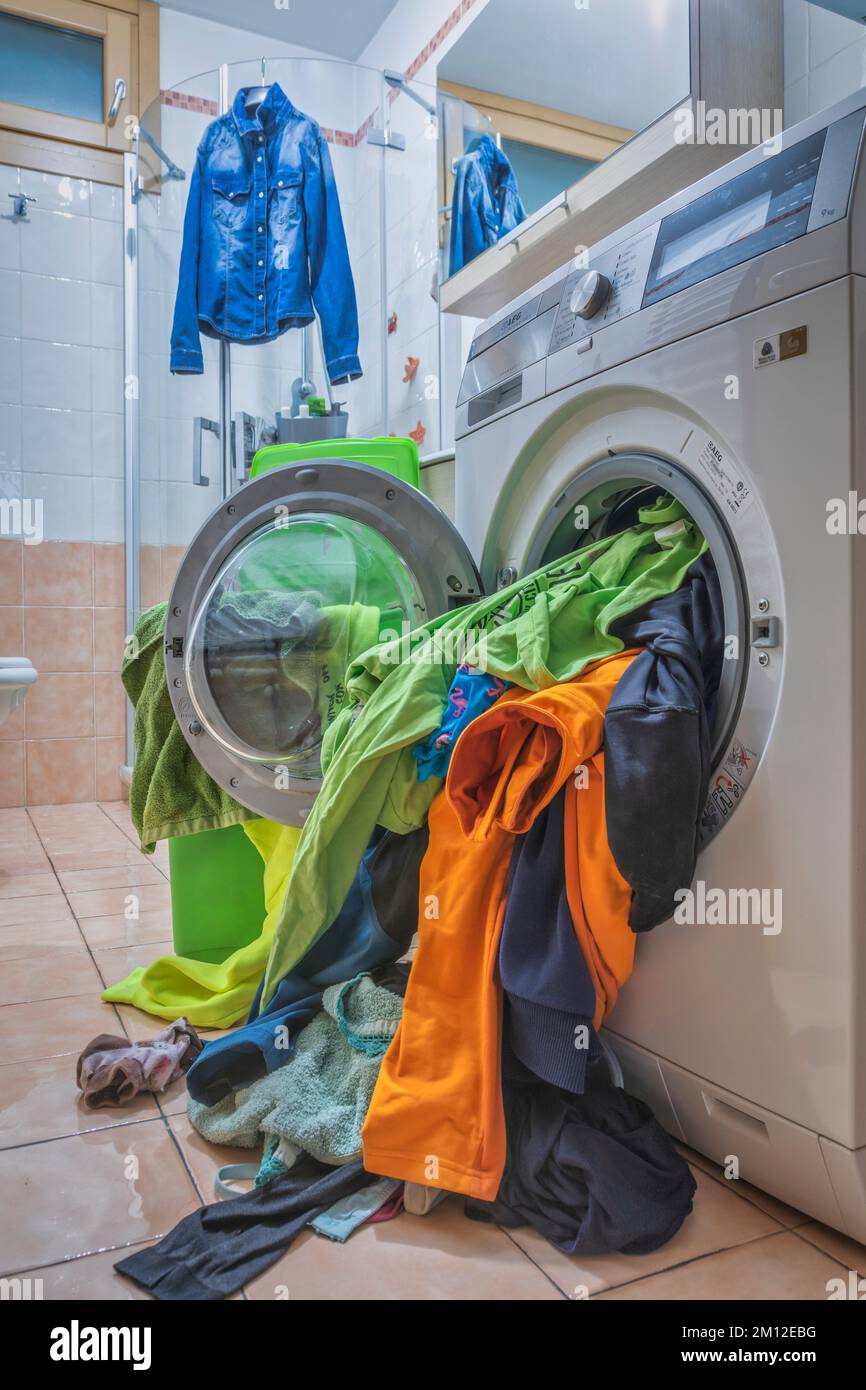 Dirty clothes lying on the floor and inside the washing machine Stock ...