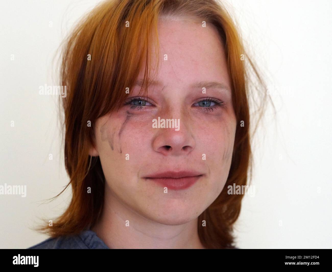 Upset Red Haired Teen Girl Smiles Through Tears Mascara Flows Down Her Cheeks Portrait Stock