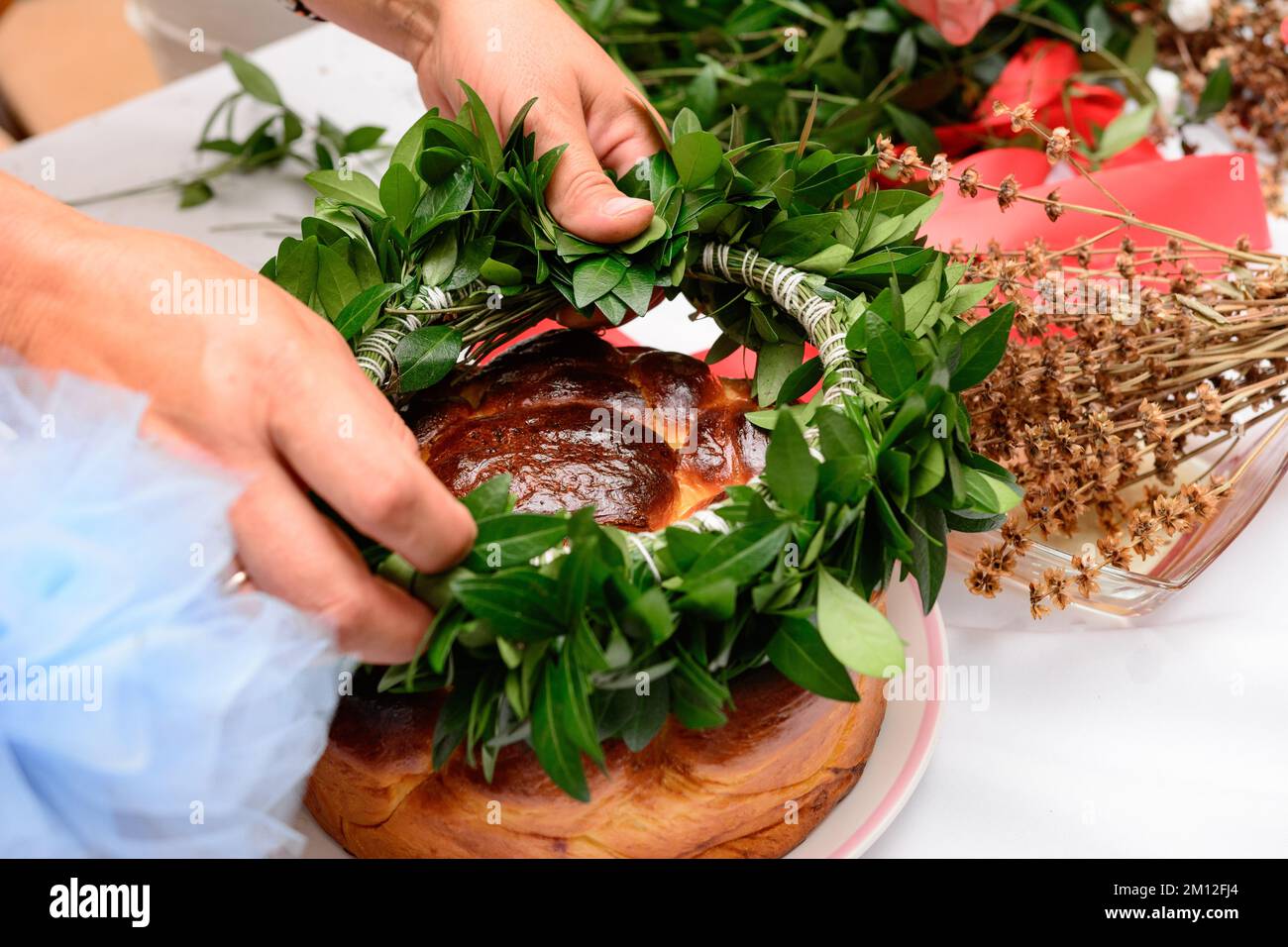 The process of weaving a periwinkle wreath, which is a traditional ...