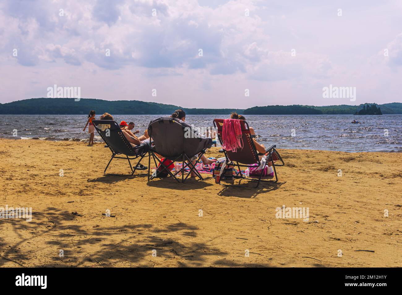 August 2021, Muskoka, Ontario, Canada - Families relaxing on beach ...