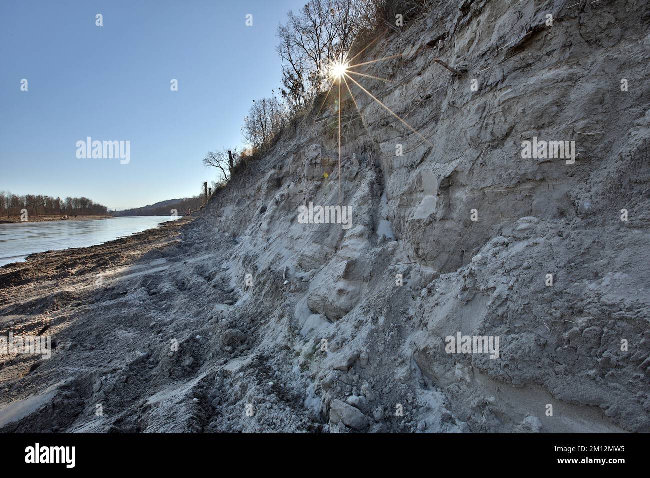 Steep wall of sand and dredge marks on a river bank, renaturation of ...