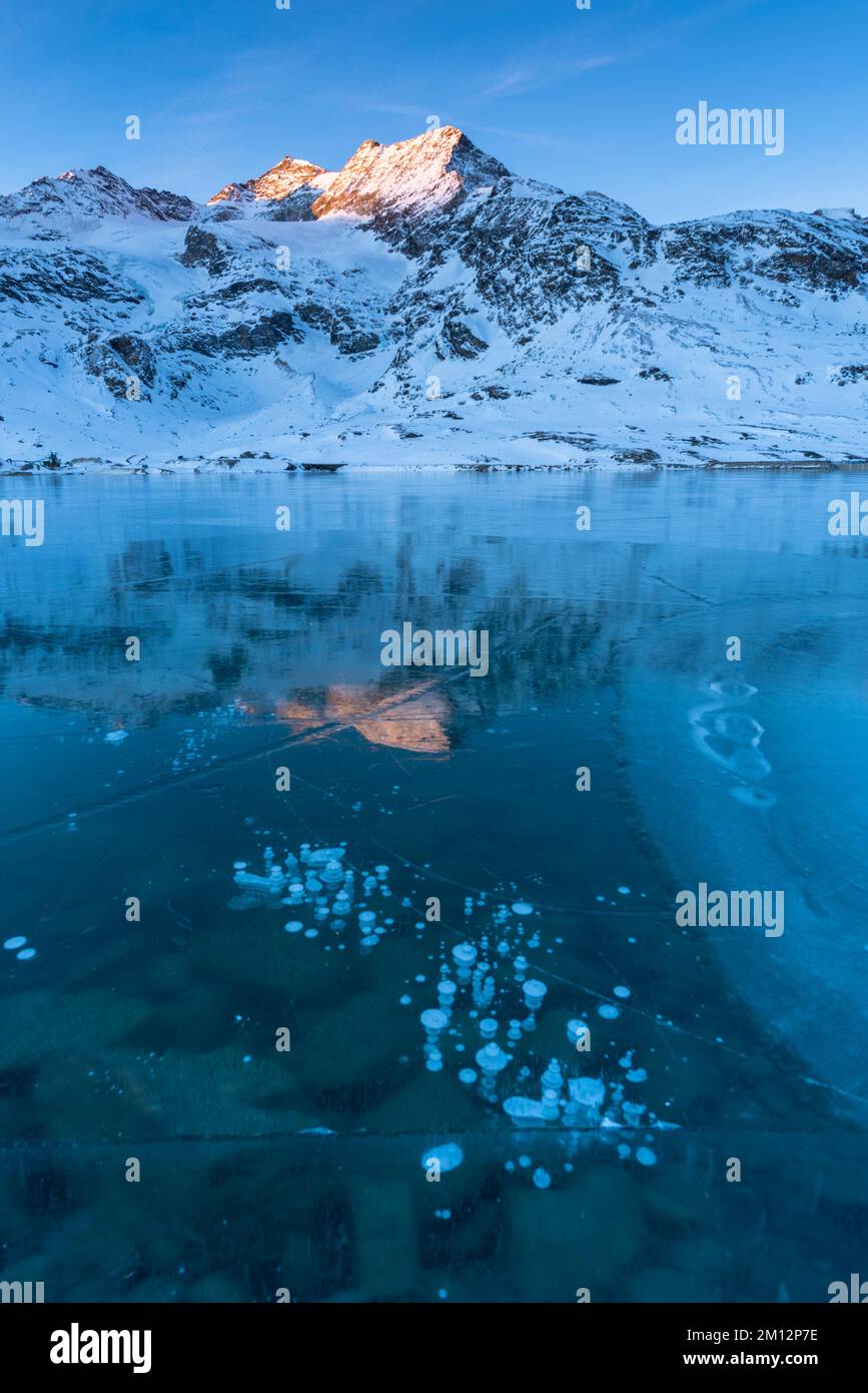 Frozen air bubbles in the black ice of the frozen Lago Bianco in the ...