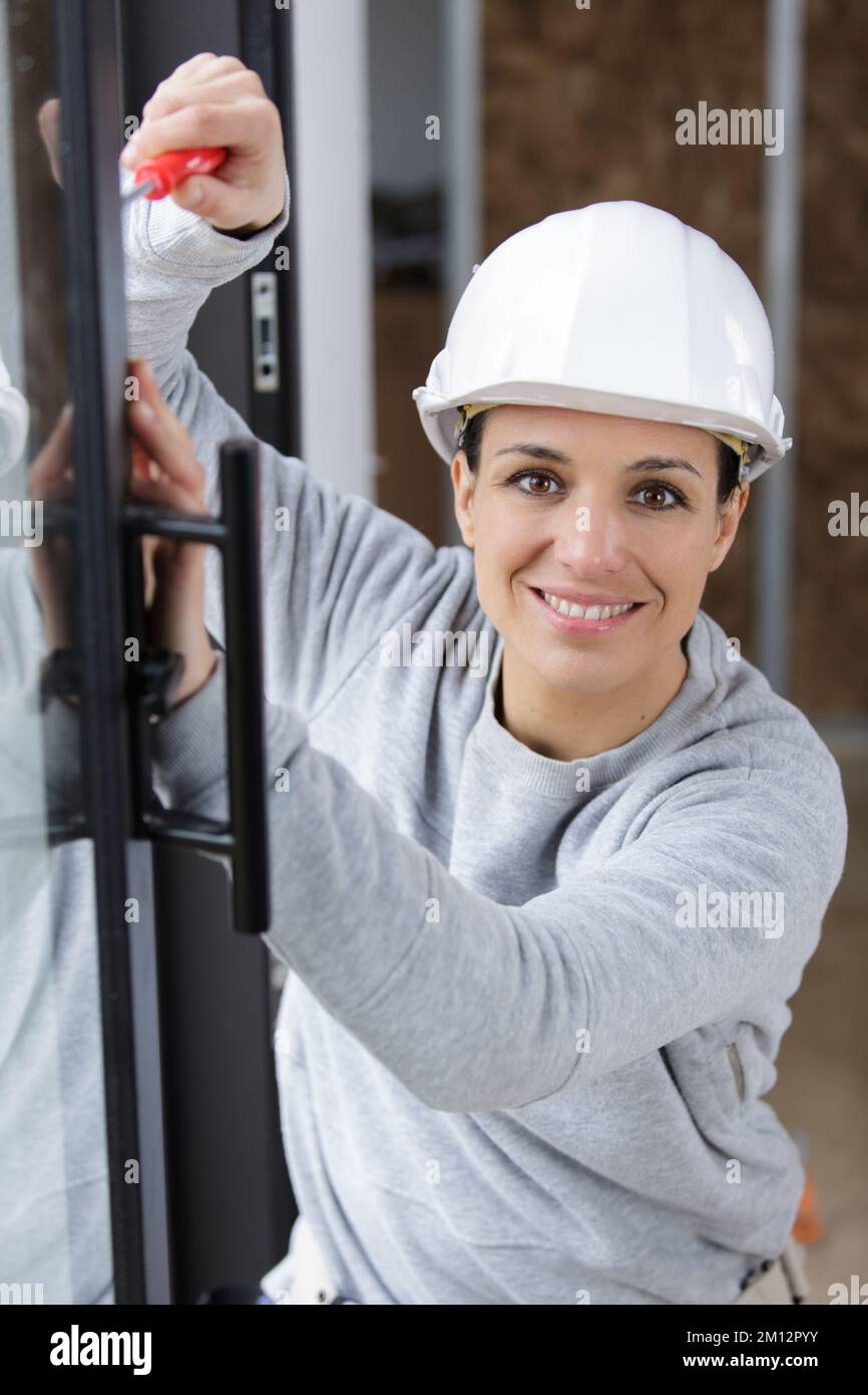 female worker fixing the window with screwdriver Stock Photo - Alamy