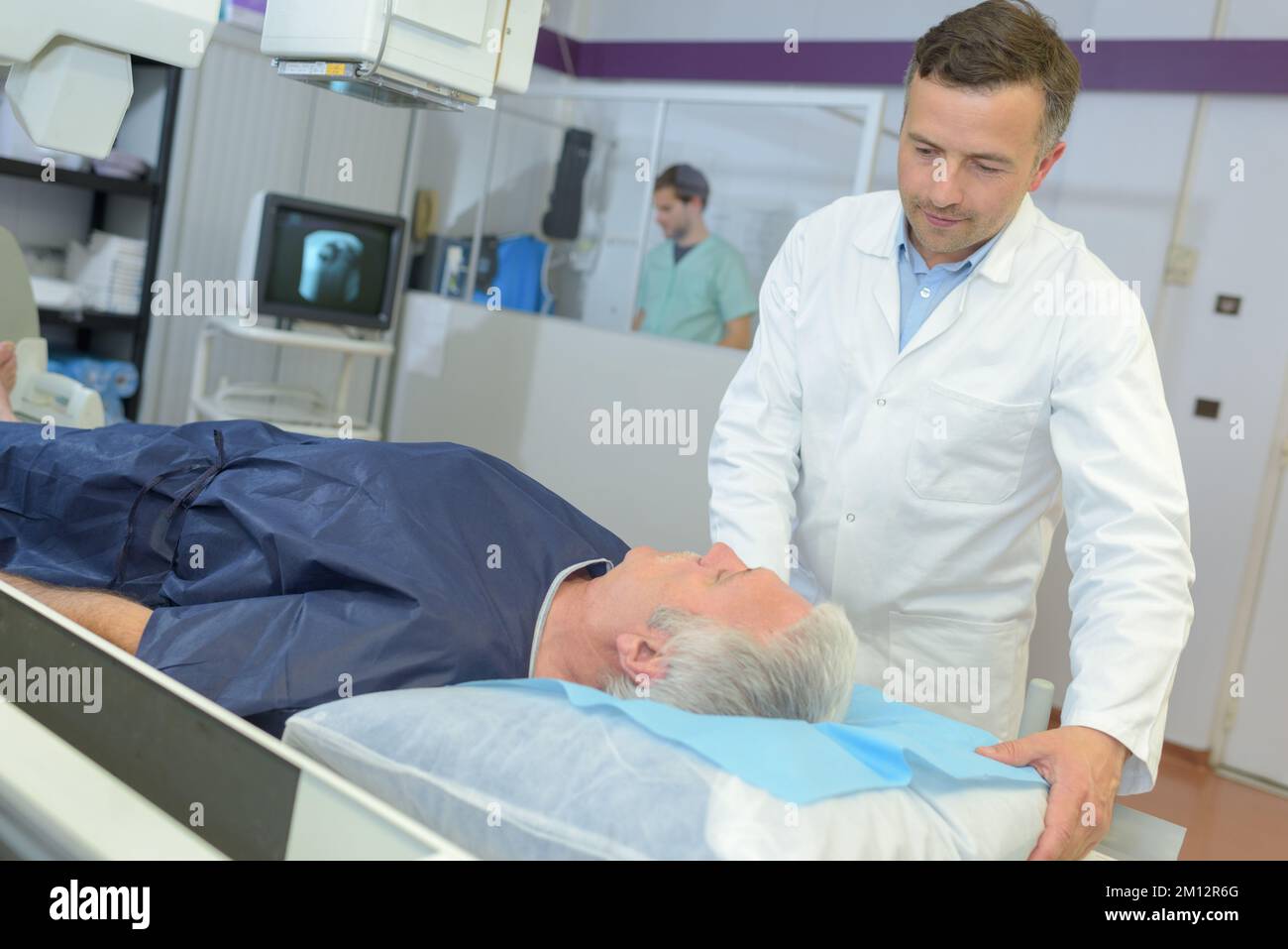 radiologist adjusting xray machine over man Stock Photo - Alamy