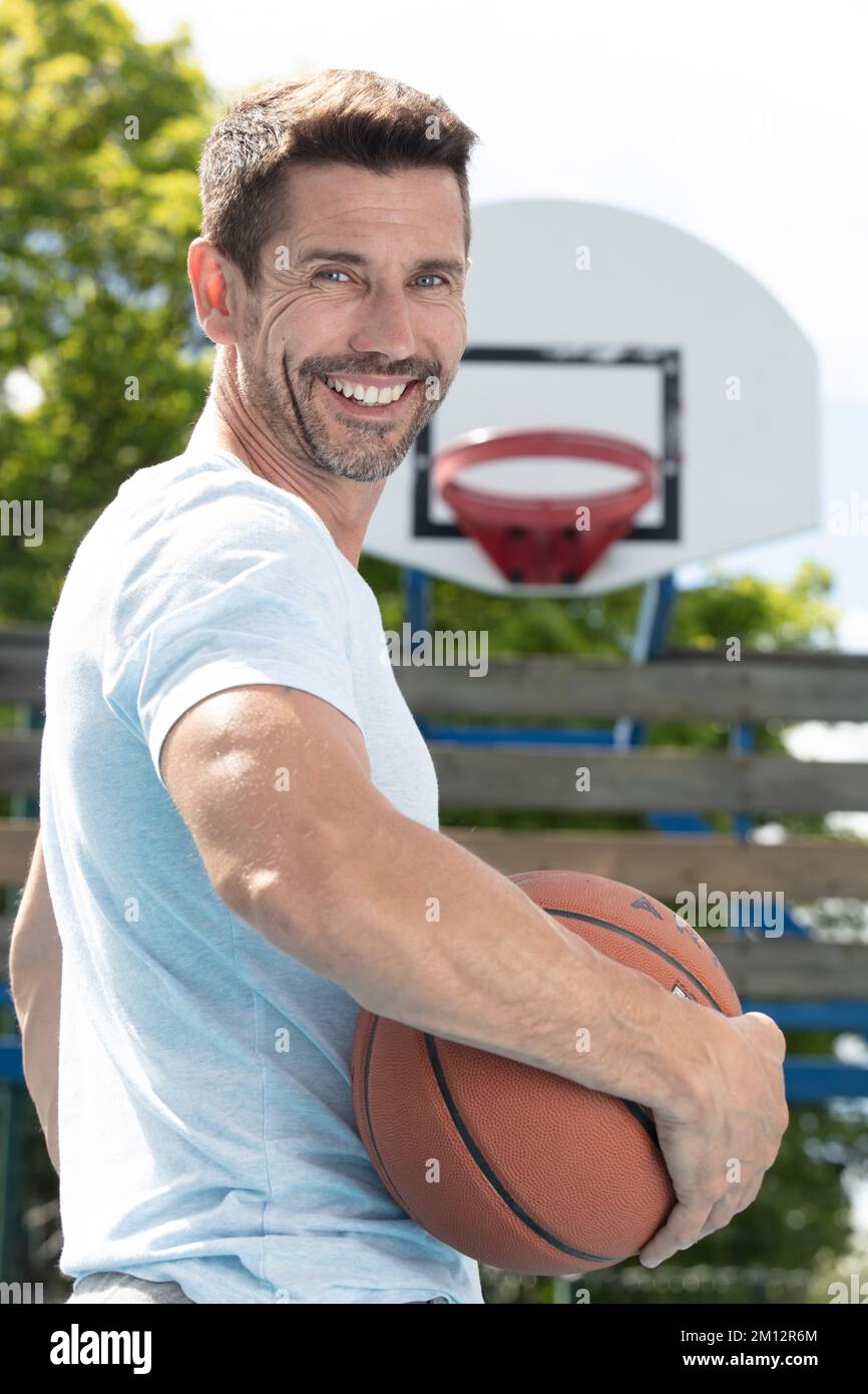 portrait of smiling basketball player standing street court Stock Photo ...