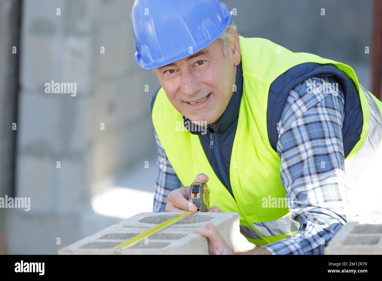 mature male builder measuring a concrete wall Stock Photo - Alamy