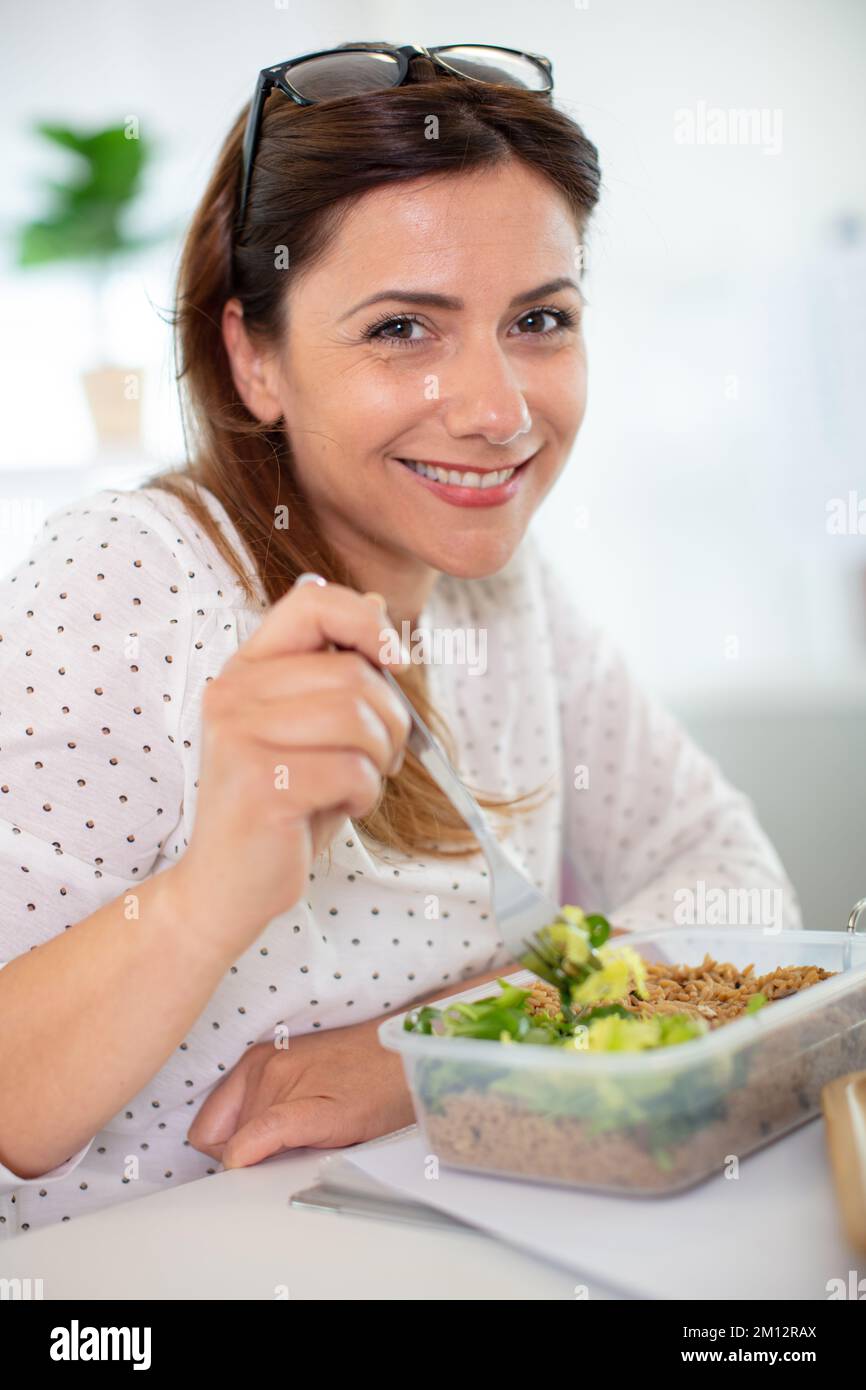 woman eating food during lunch break at office Stock Photo - Alamy