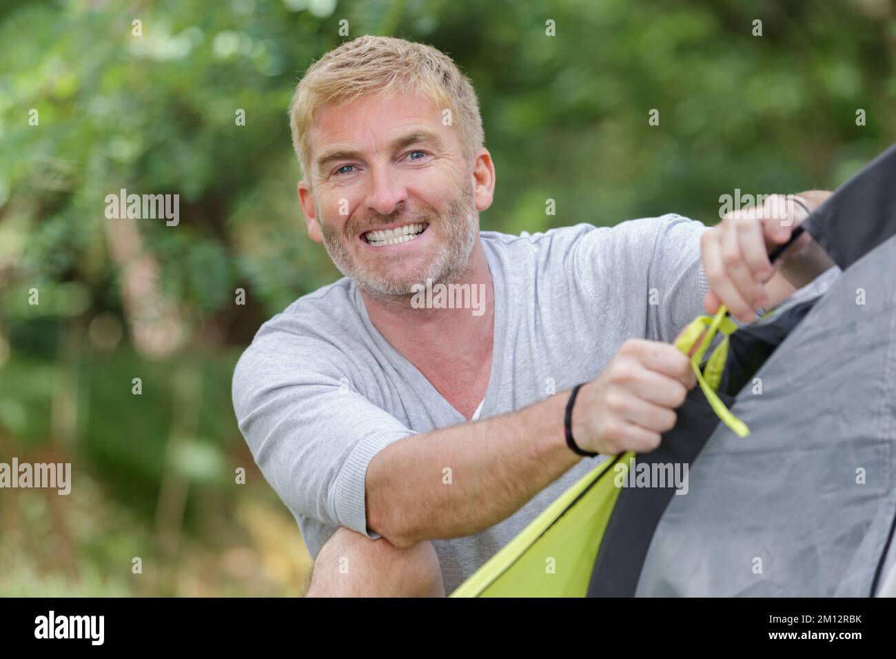 man during tent set up tent Stock Photo - Alamy