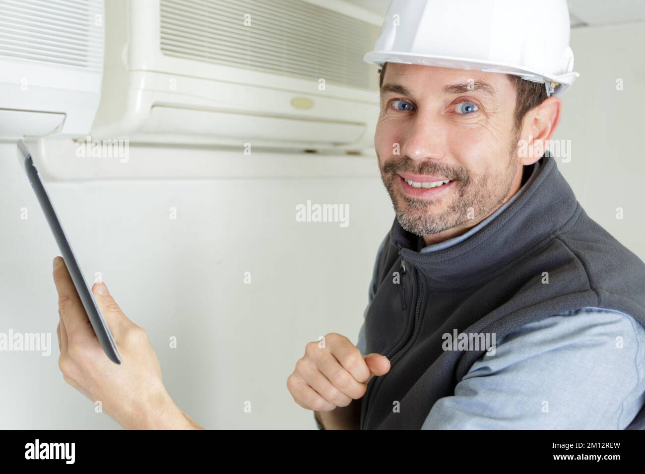 a man is checking airconditioning Stock Photo - Alamy