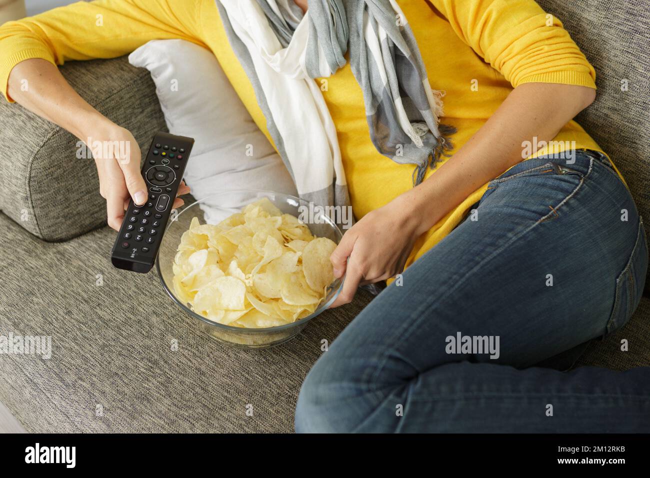 woman on sofa eating crisps while watching tv Stock Photo - Alamy