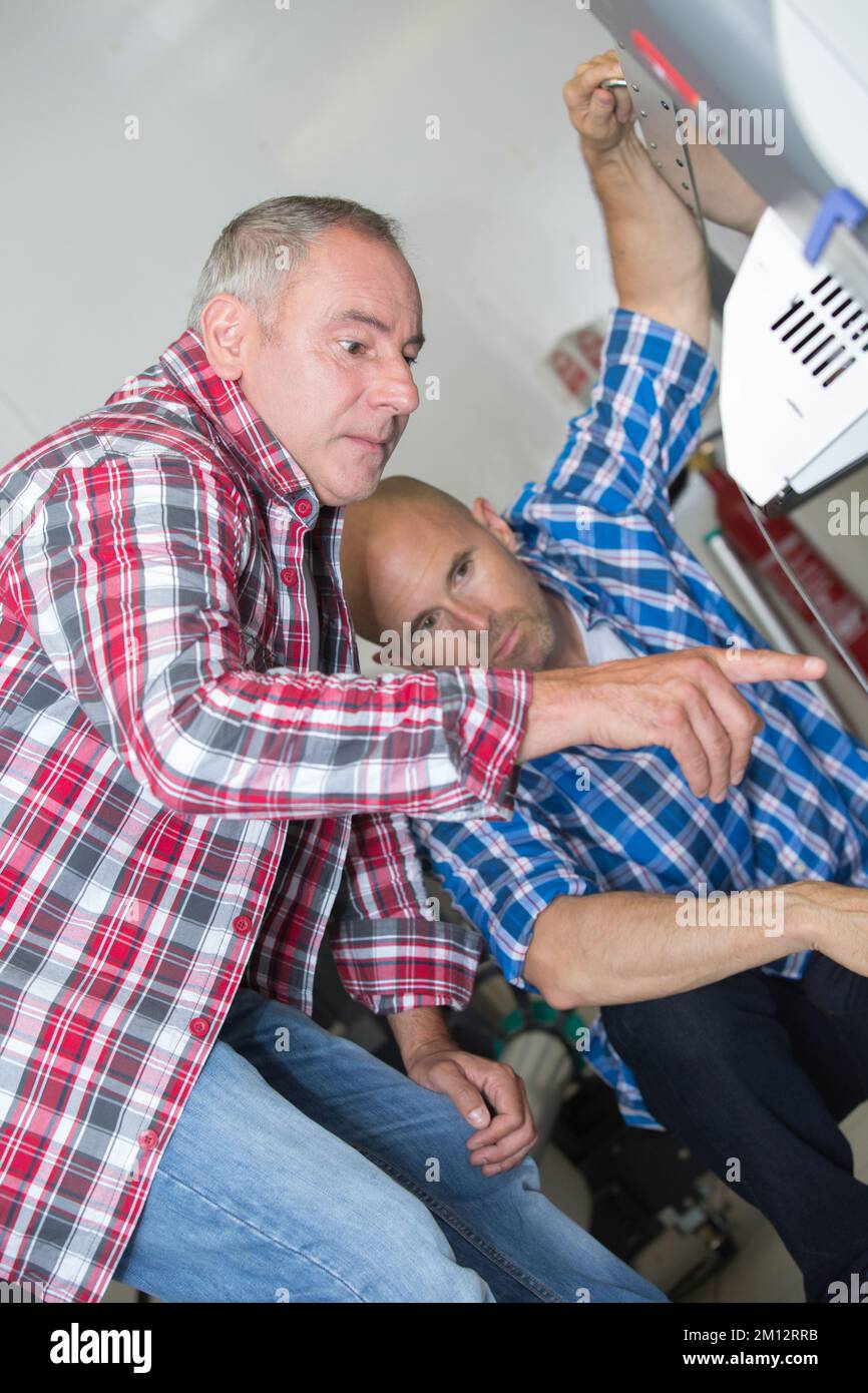 two men looking at electrical appliance Stock Photo - Alamy