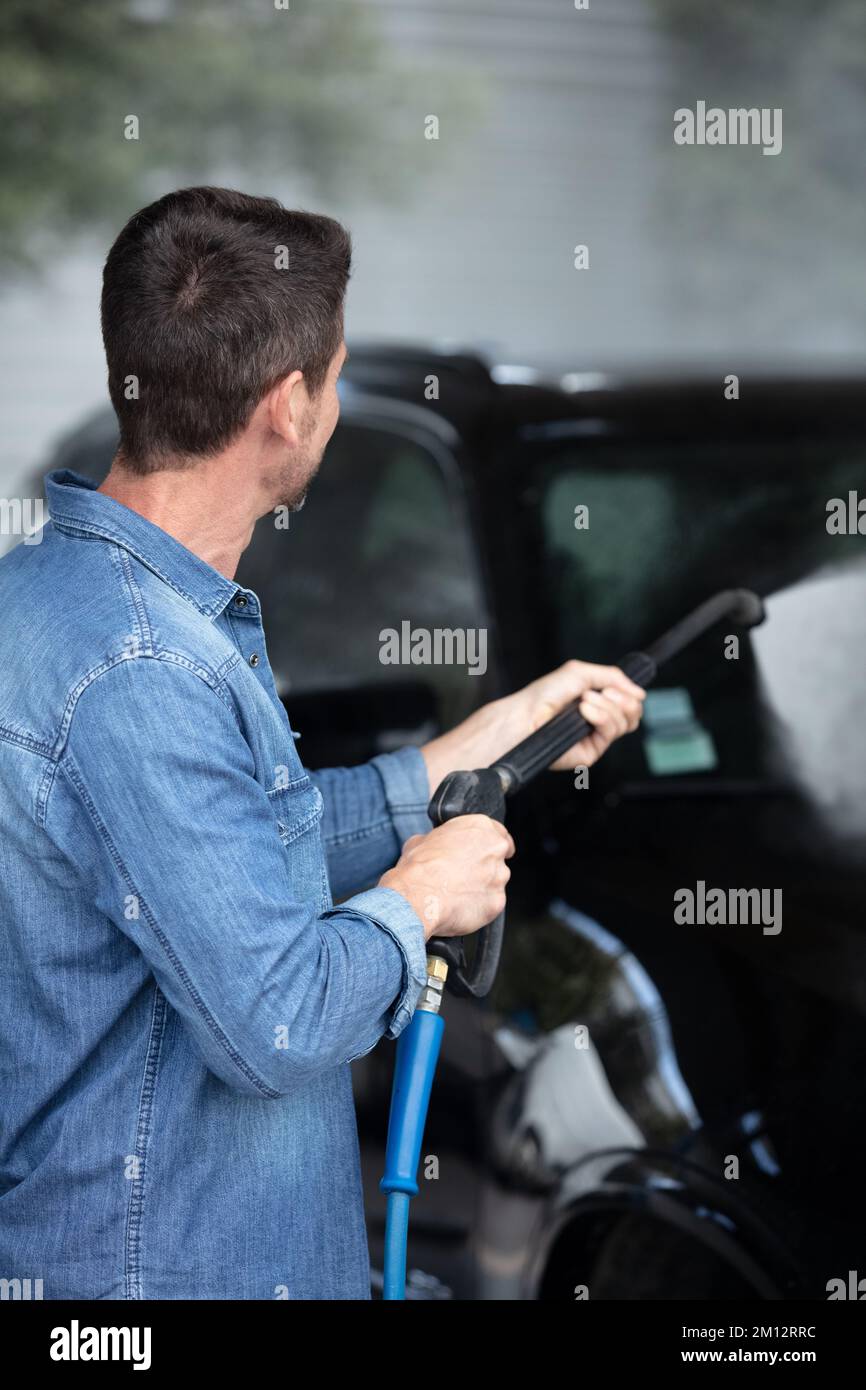 man worker washing car on a car wash Stock Photo - Alamy