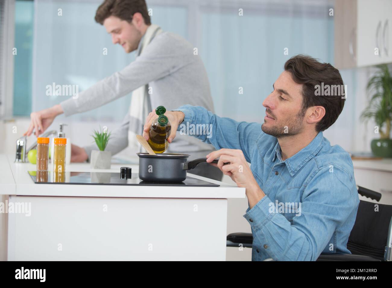 disabled man in wheelchair cooking a meal in the kitchen Stock Photo ...