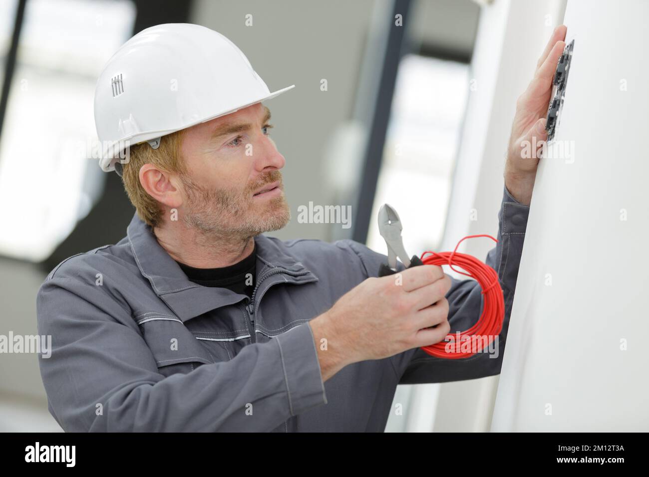 an electrician is installing socket Stock Photo - Alamy