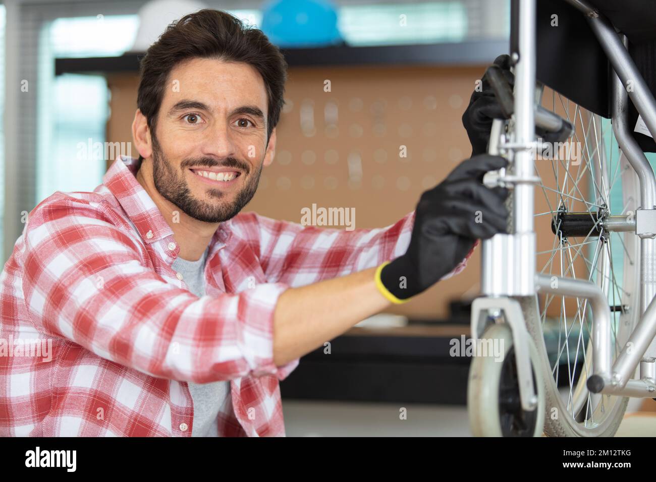 handsome young man is fixing a wheelchair Stock Photo - Alamy