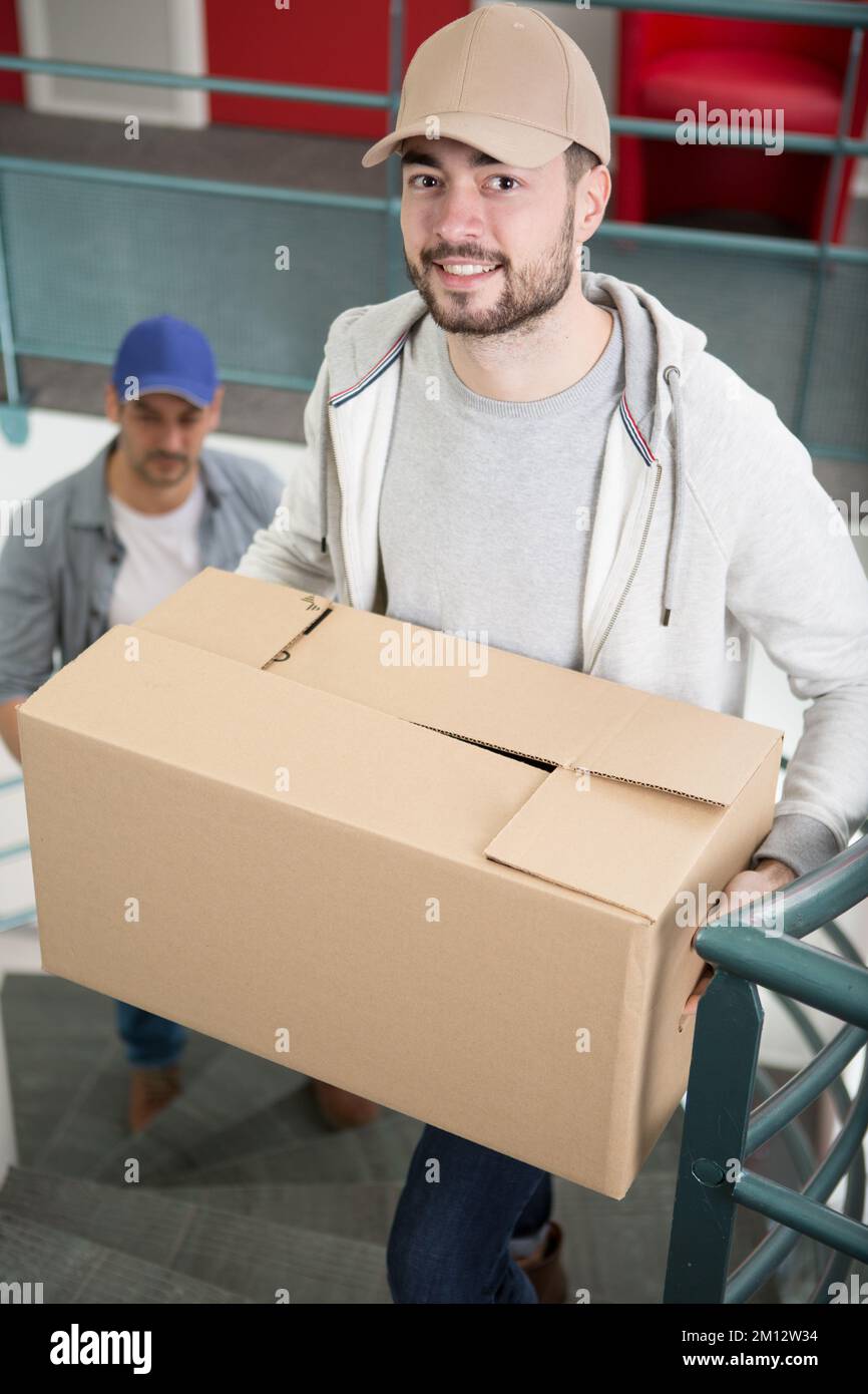 delivery man holding parcel box up the stairs Stock Photo - Alamy