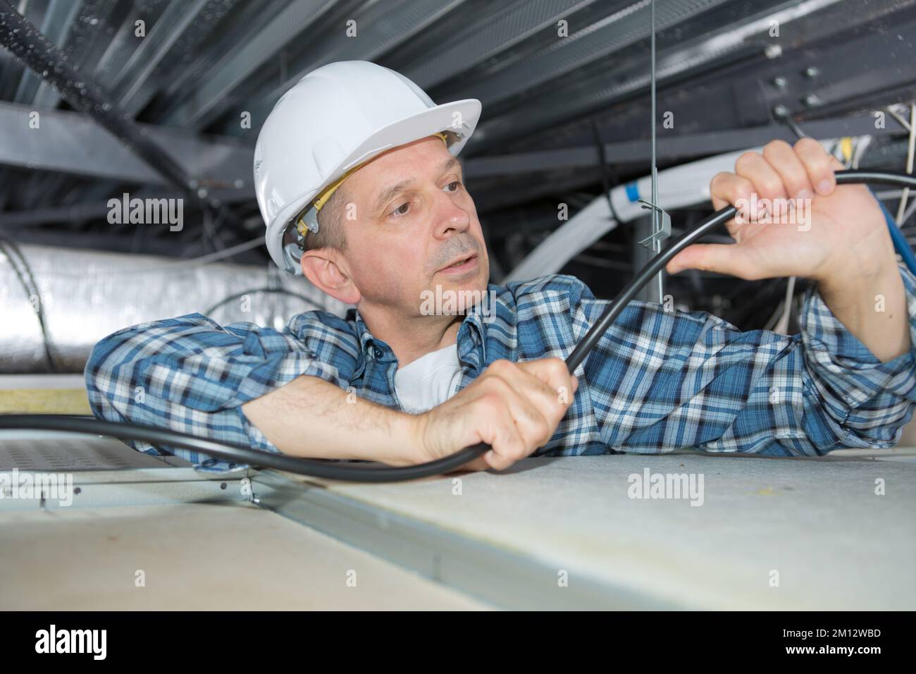 electrical worker wiring in ceiling Stock Photo - Alamy