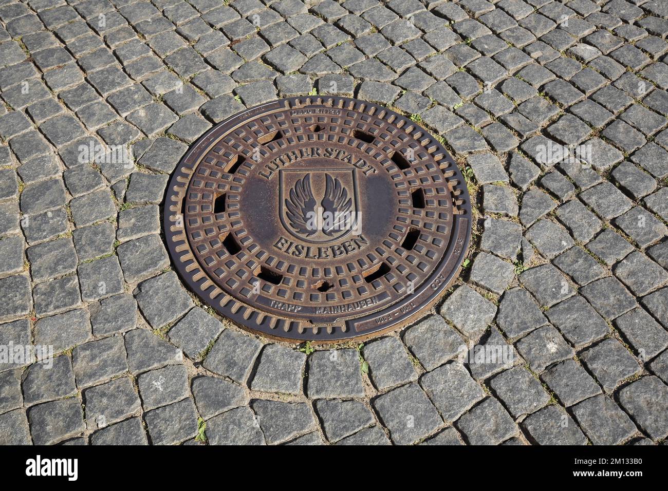 Manhole cover with paving stones on the ground, Luther city Eisleben ...