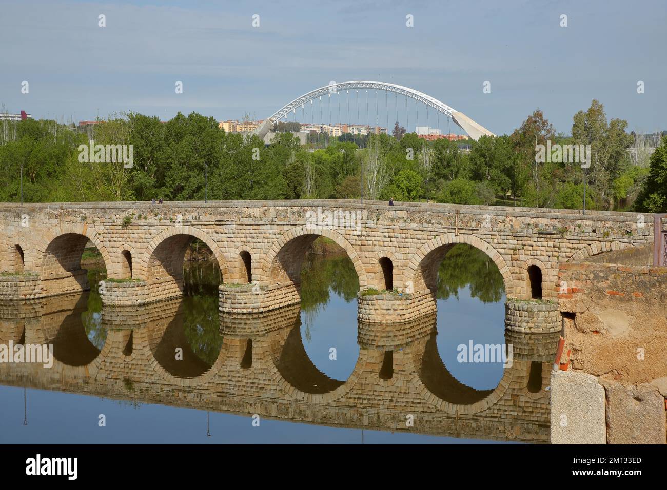 Roman stone arch bridge Puente Romano with reflection in the river Rio ...
