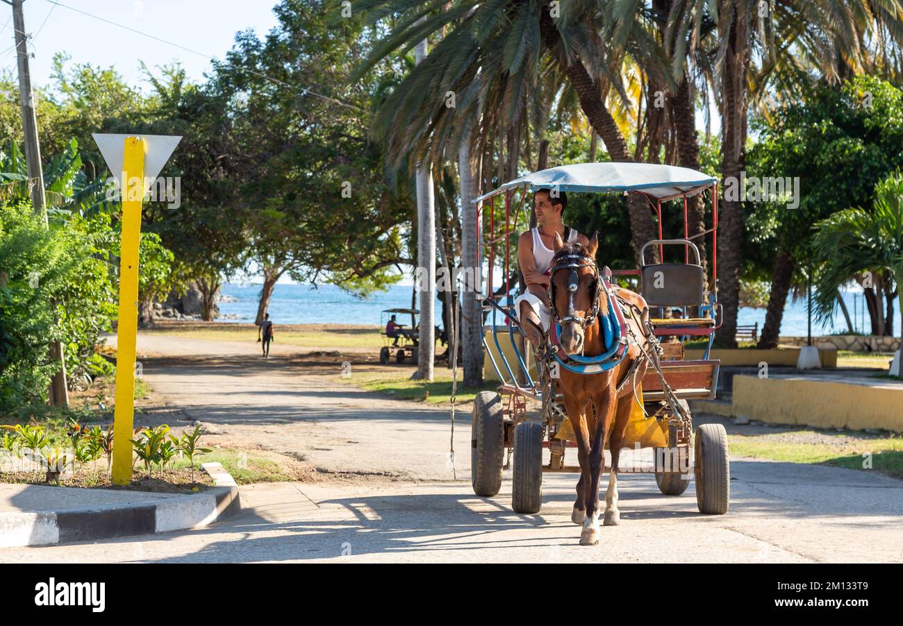 A man riding a horse carriage in a street of Santiago de Cuba on a ...