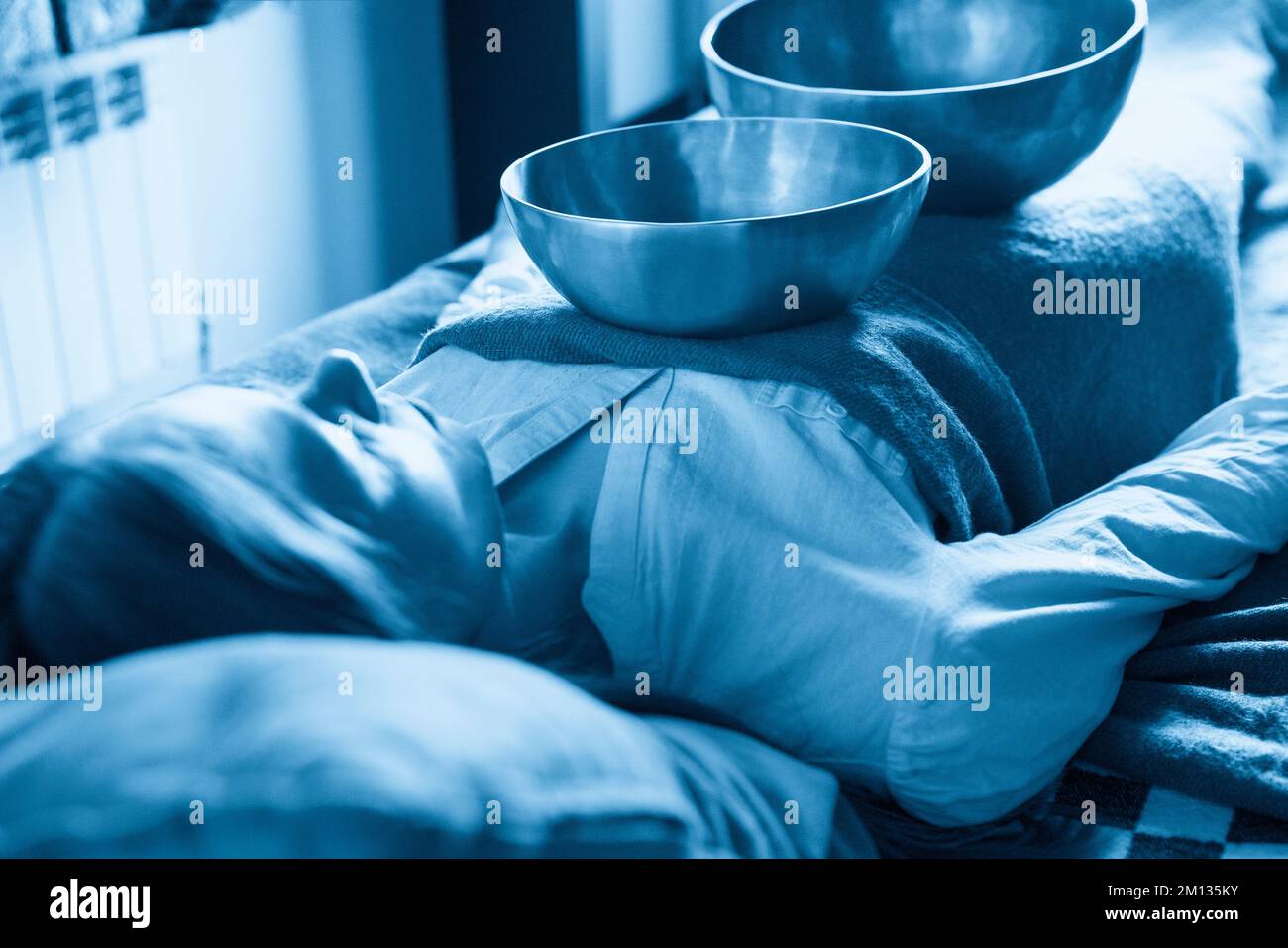 Tibetan singing bowls in sound therapy in spa center over a woman body ...
