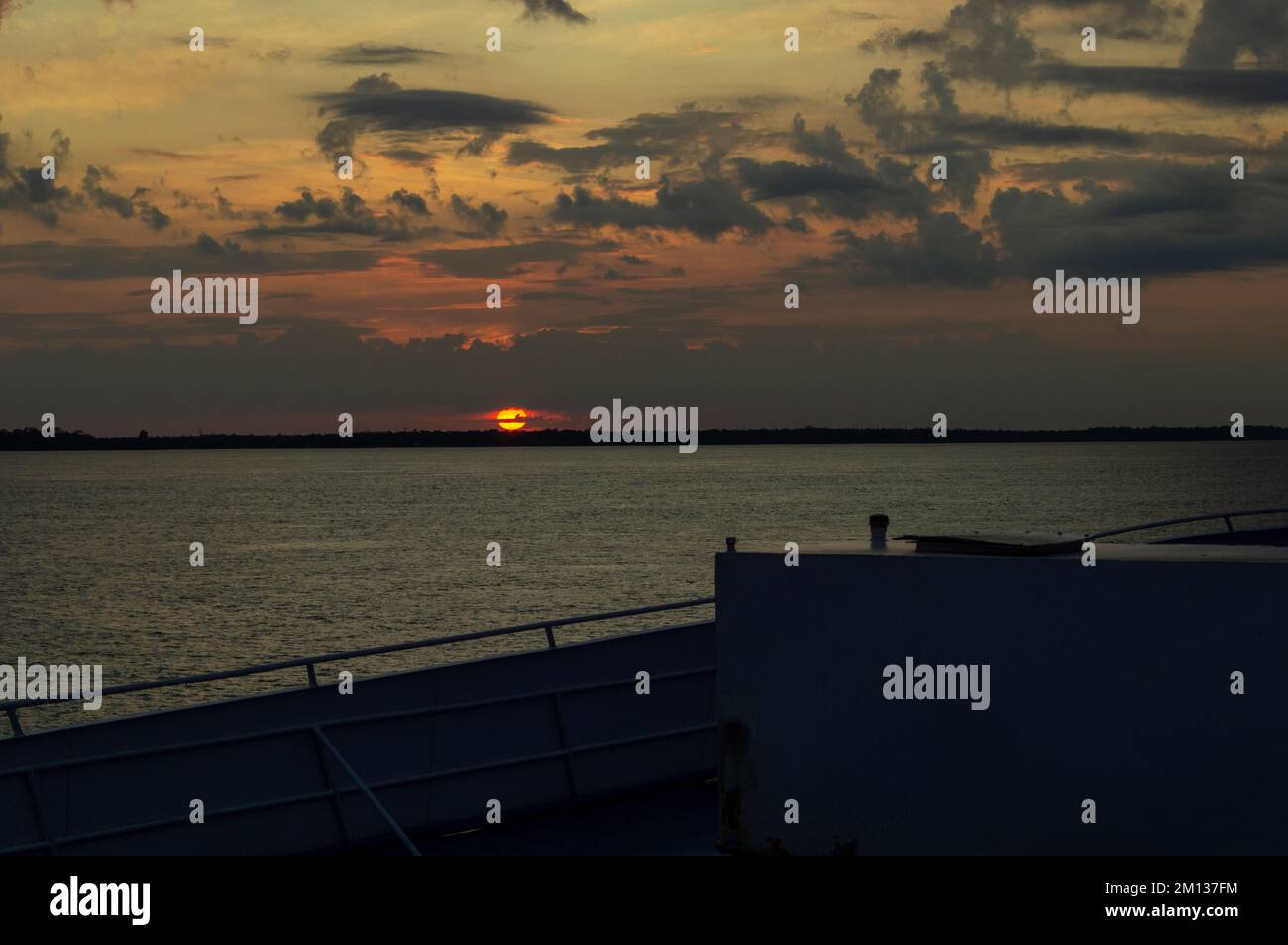 Sun rise on the Amazon river during a night trip on a boat Stock Photo ...