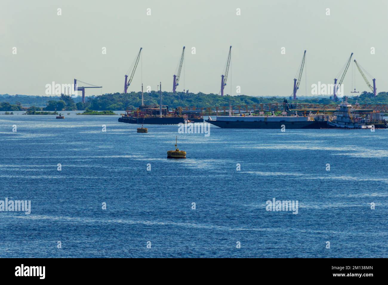 Industrial site on the river banks of Rio Amazonas in Brazil surrounded ...