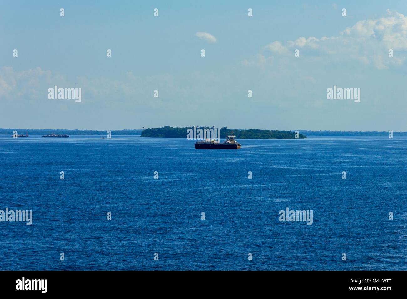 Cargo ships travelling along the Amazonas river in Brazil along the ...