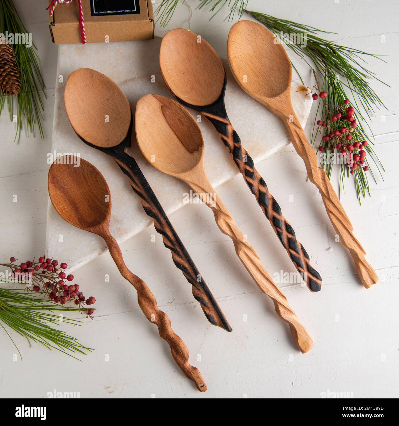 Wooden carved spoons with christmas decoration on white marble table ...