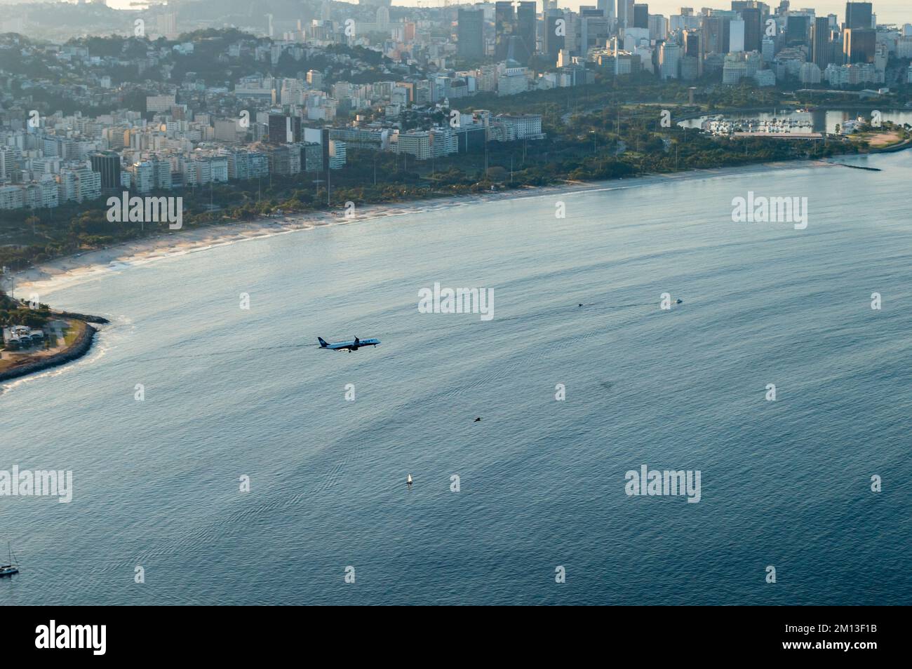 Aerial view of Rio de Janeiro northern area with a plane landing in the ...