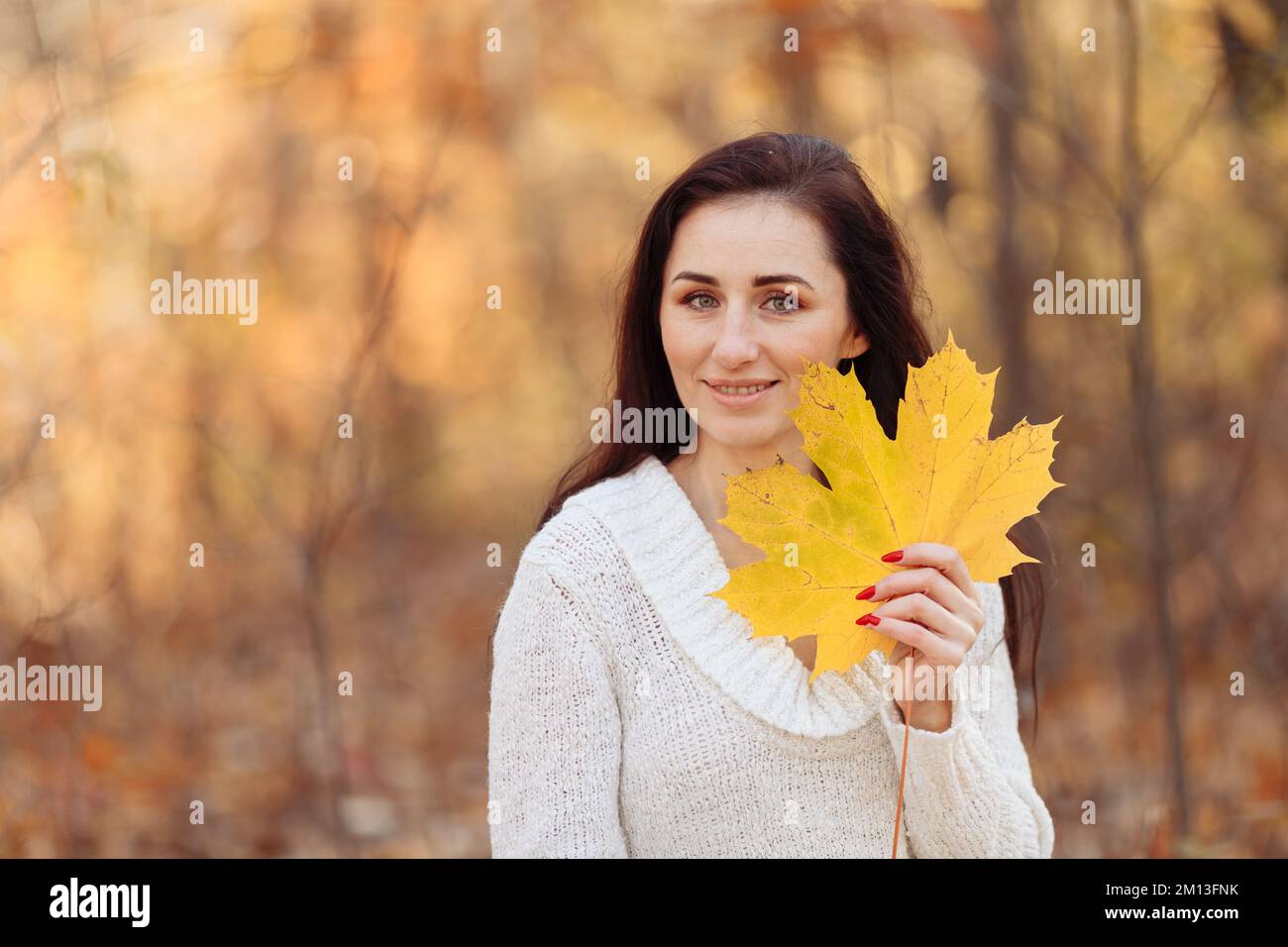 Side view of pleased brunette woman in eyeglasses sitting on bench and ...
