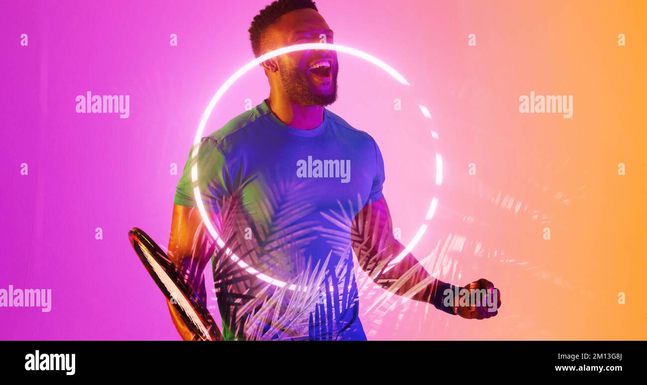 African american male player with racket screaming by illuminated ...