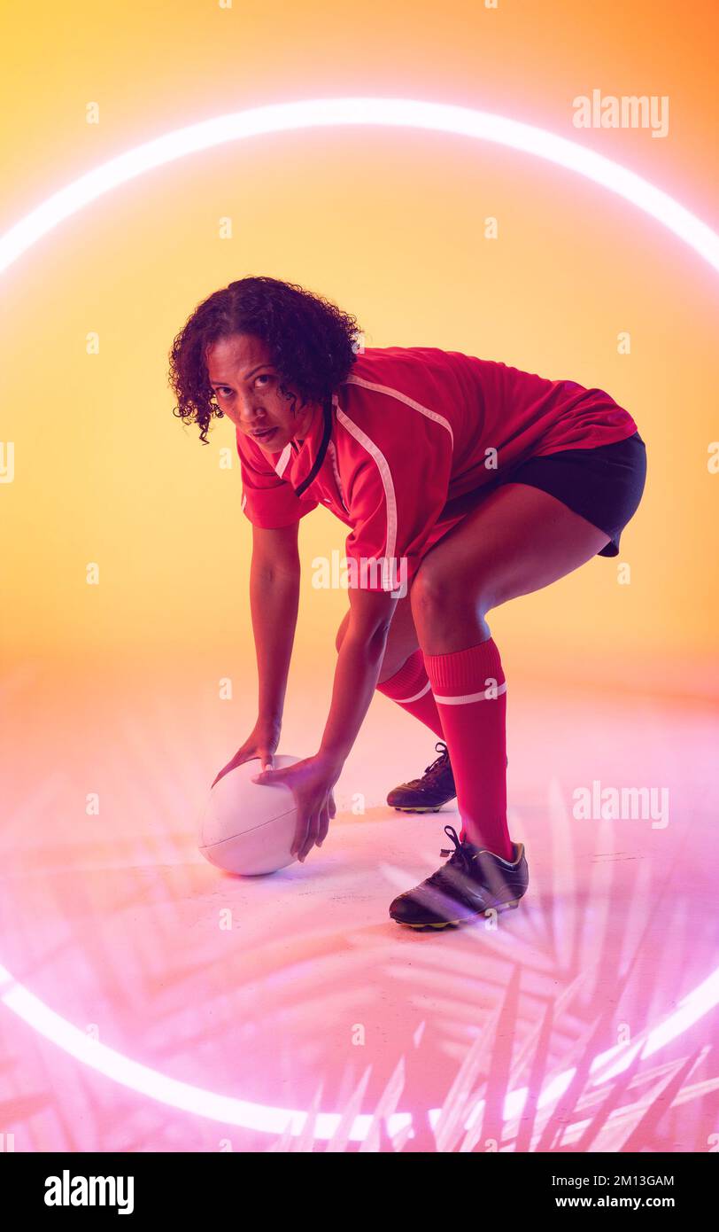 Composite of biracial female rugby player with ball bending over ...