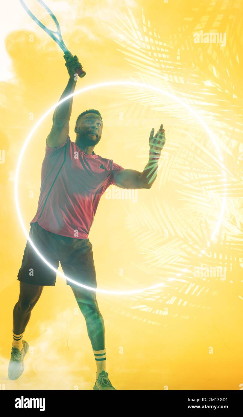 African american male tennis player hitting ball with racket by ...